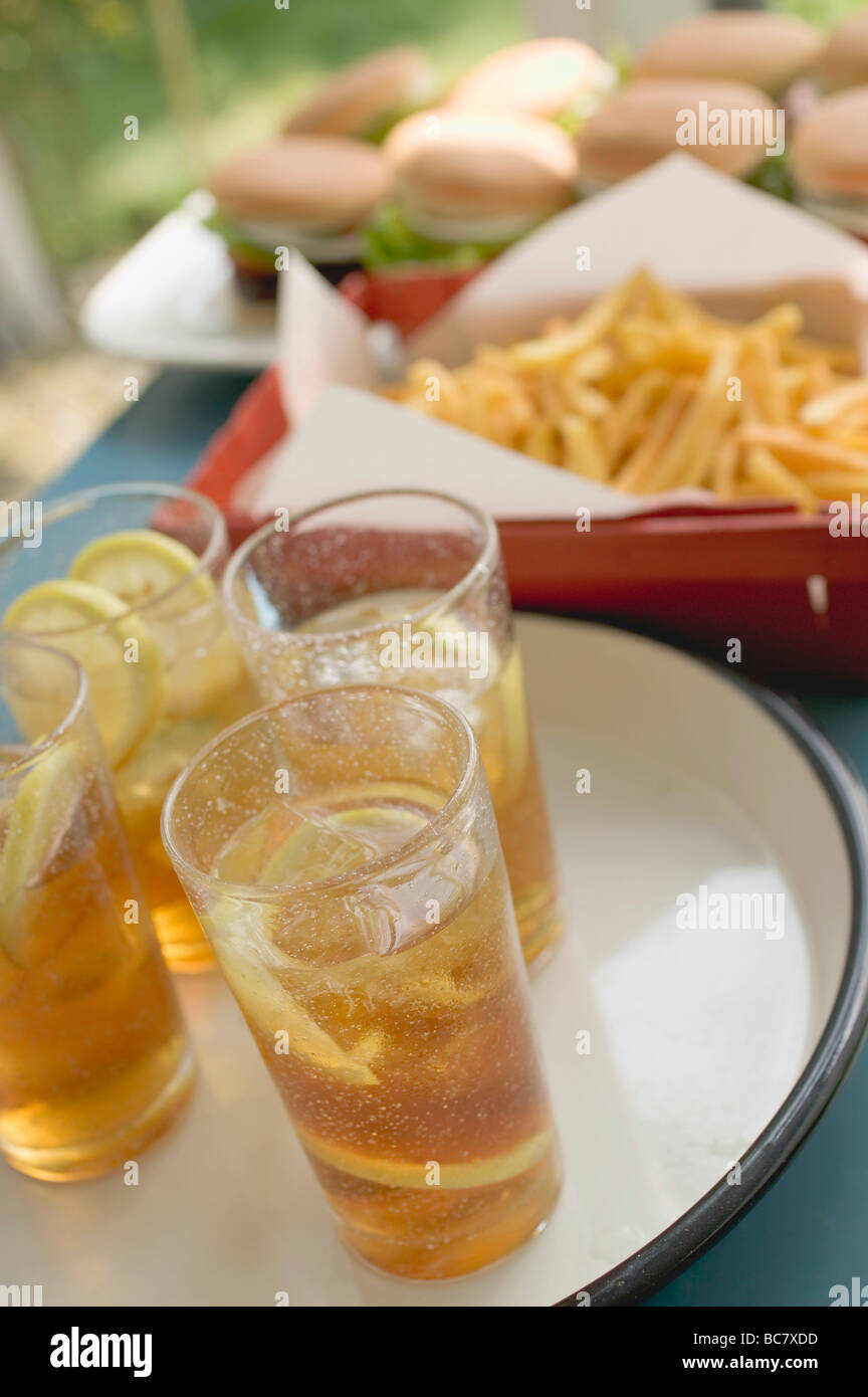 Iced tea, chips and hamburgers on table out of doors Stock Photo - Alamy