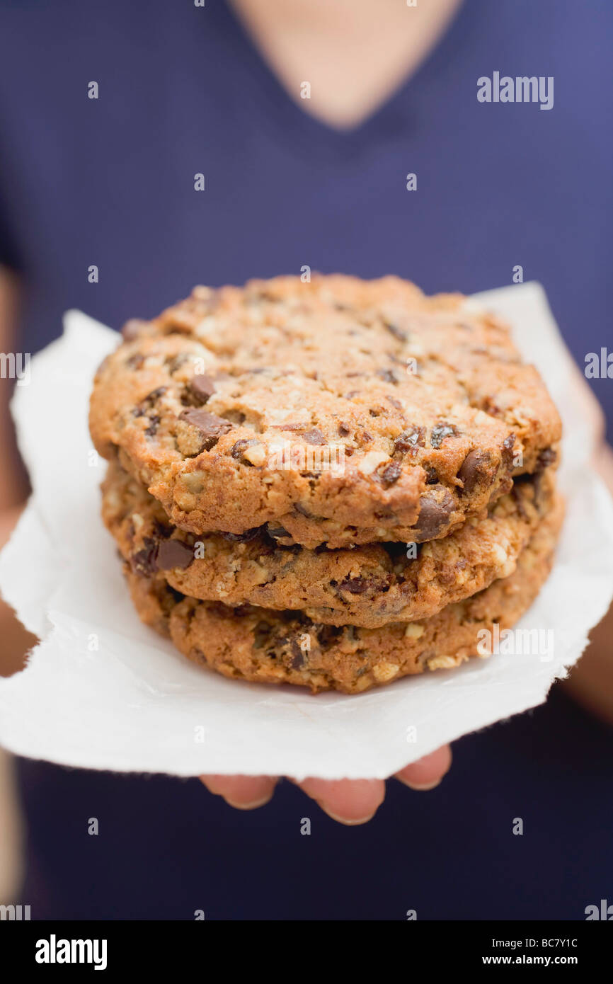 Woman holding large chocolate chip cookies on paper Stock Photo - Alamy