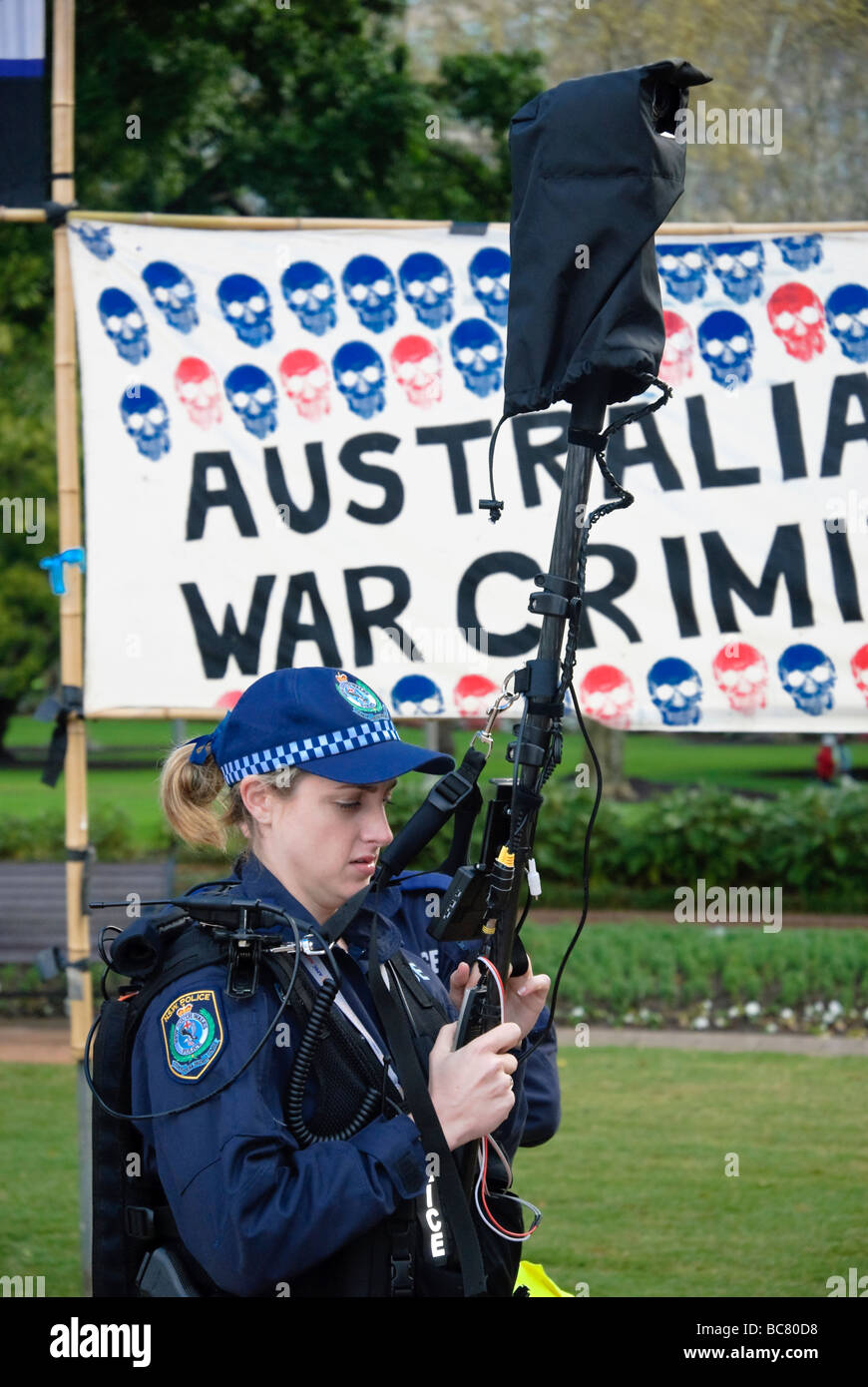 Female police officer using a surveillance video camera on a tall pole ...