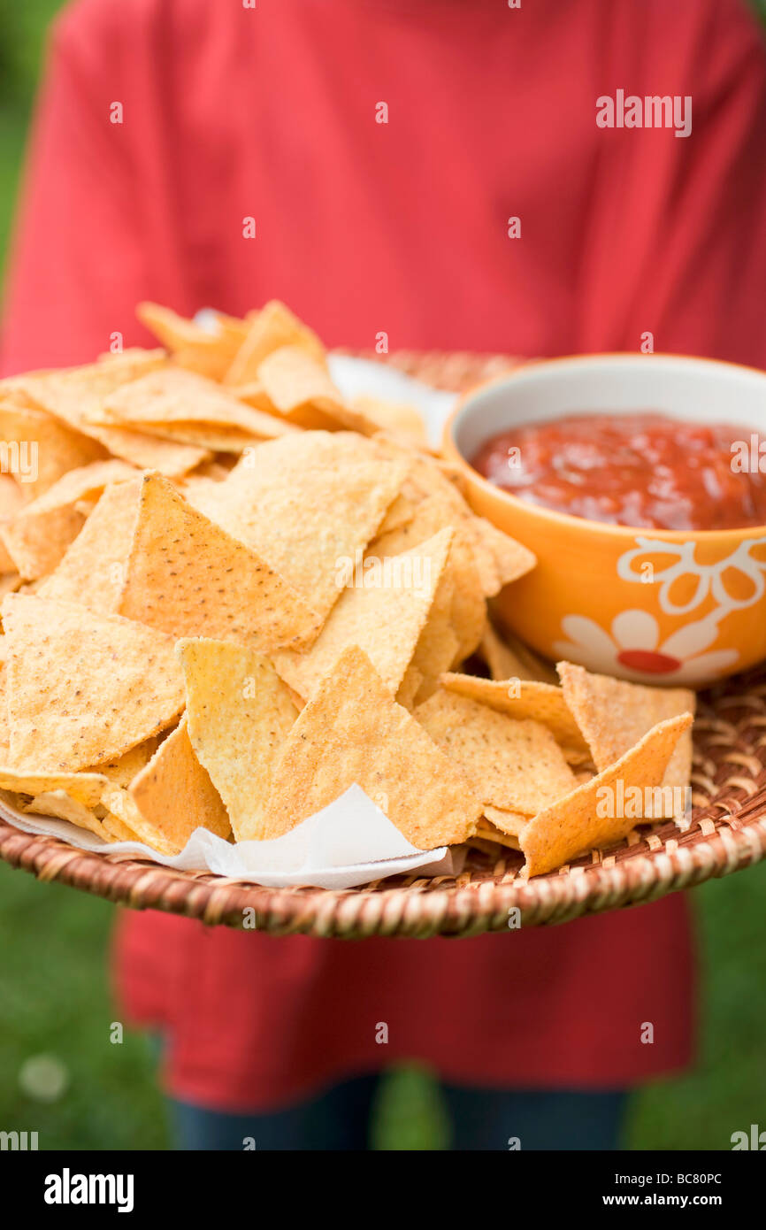 Person holding tray of nachos and salsa Stock Photo - Alamy