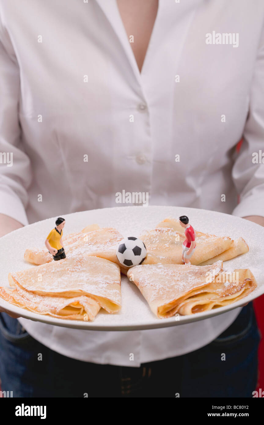 Woman serving plate of sweet crêpes with football figures Stock Photo ...
