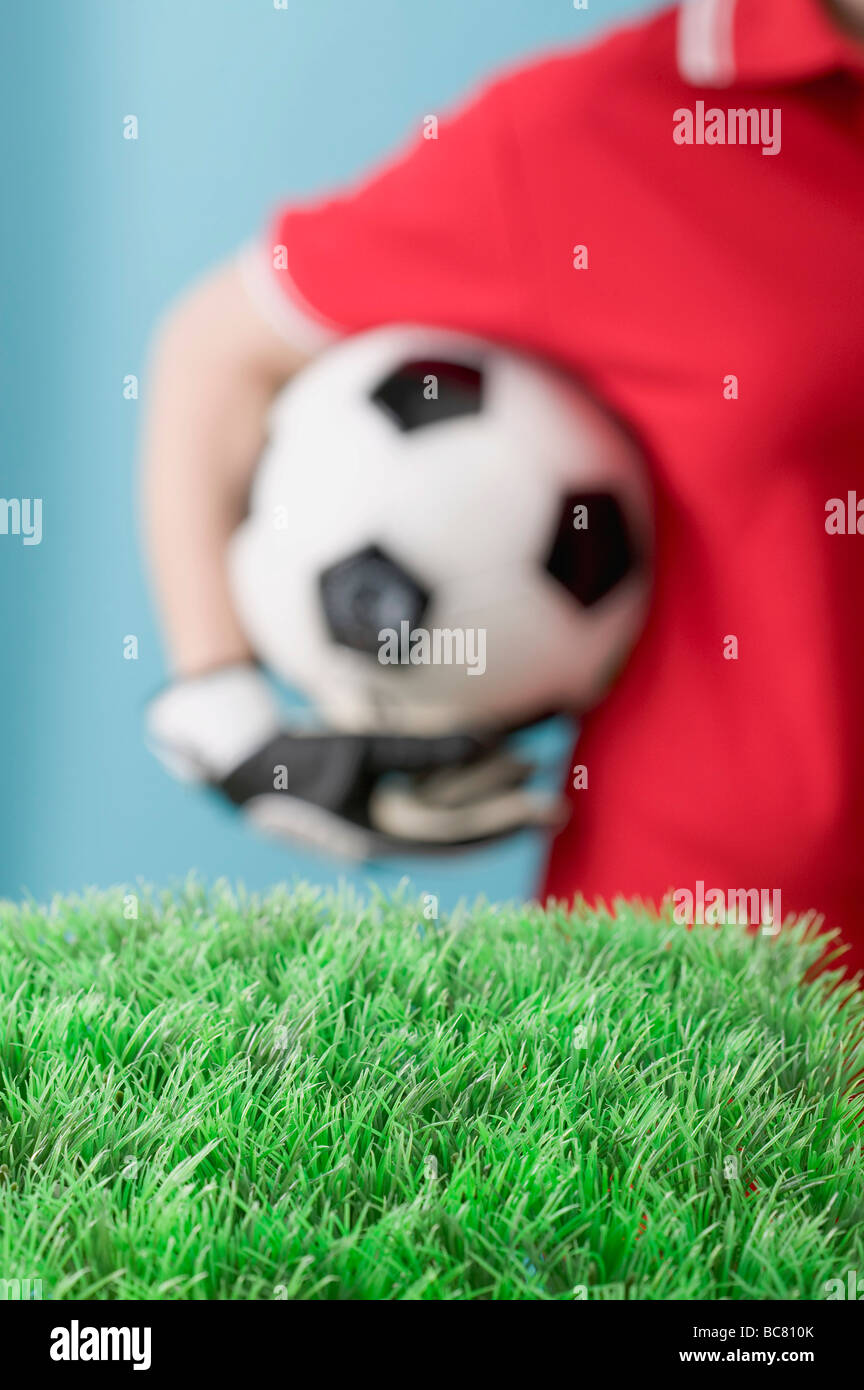 Footballer behind artificial turf Stock Photo - Alamy