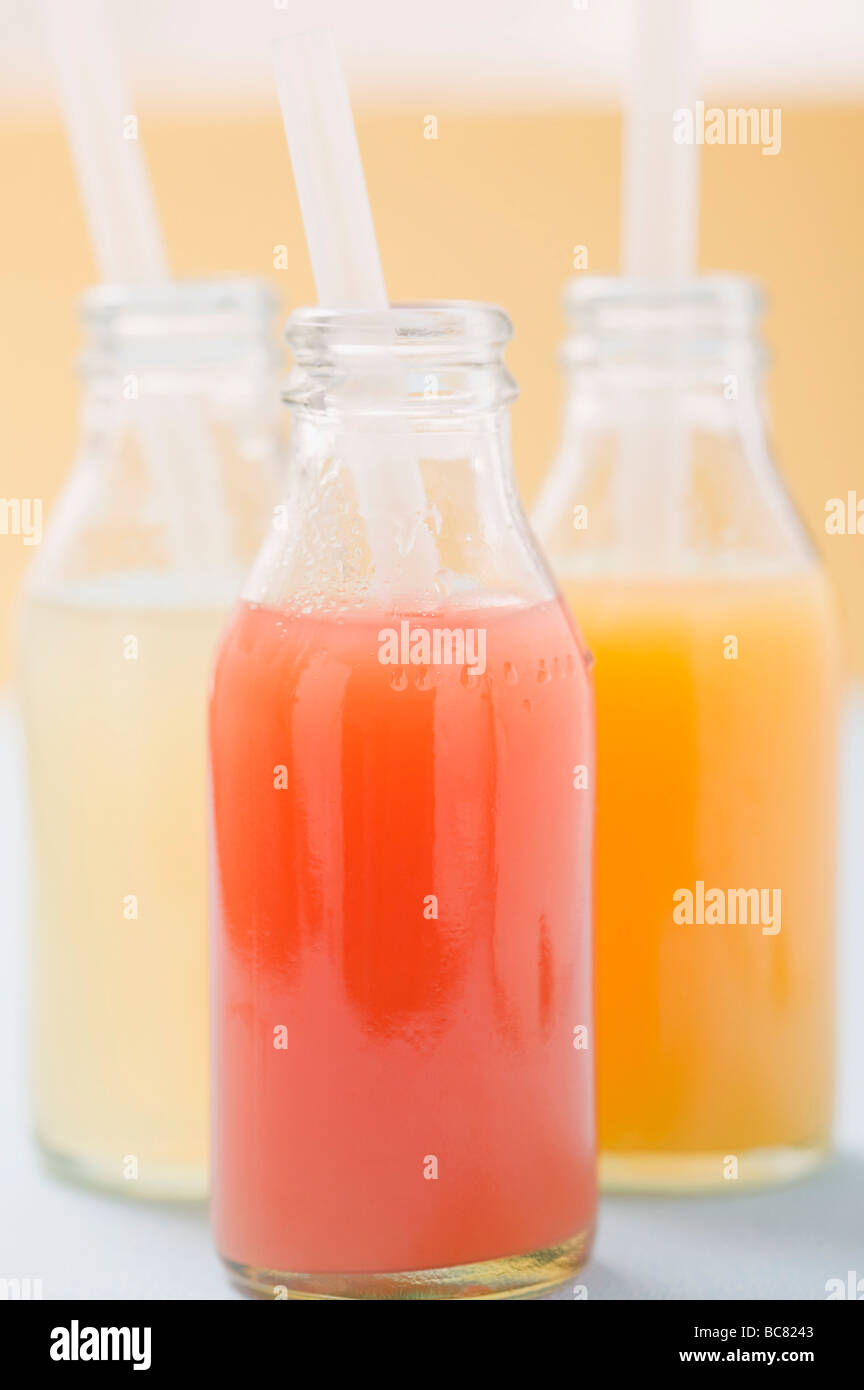 Three fruit juices in bottles with straws Stock Photo - Alamy