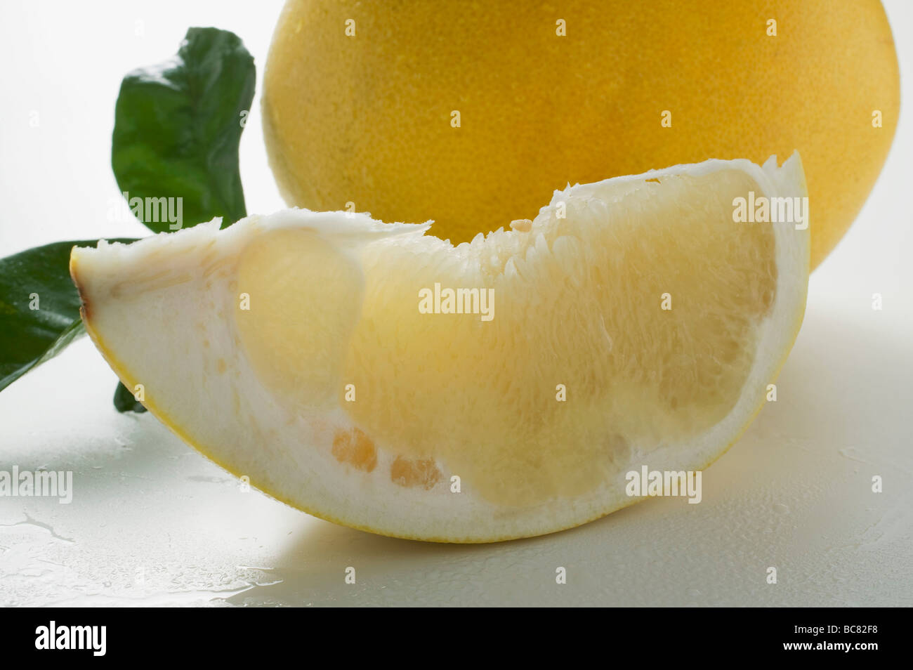 Wedge of pomelo, whole pomelo and leaves Stock Photo - Alamy