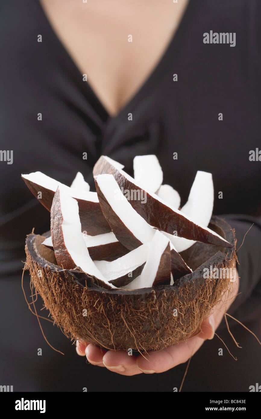 Woman holding pieces of coconut in hollowed-out coconut Stock Photo - Alamy