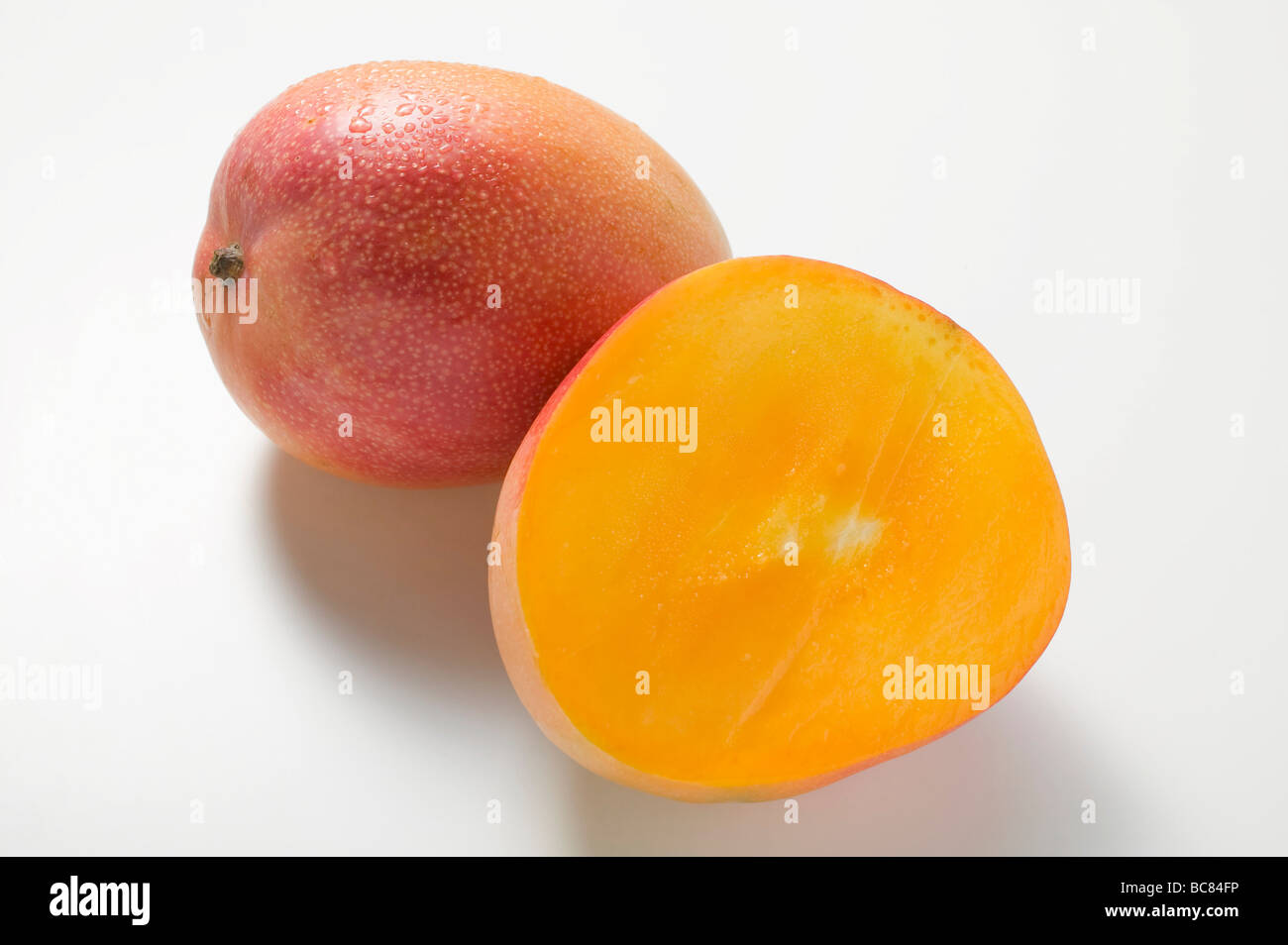 Whole mango and half a mango Stock Photo - Alamy