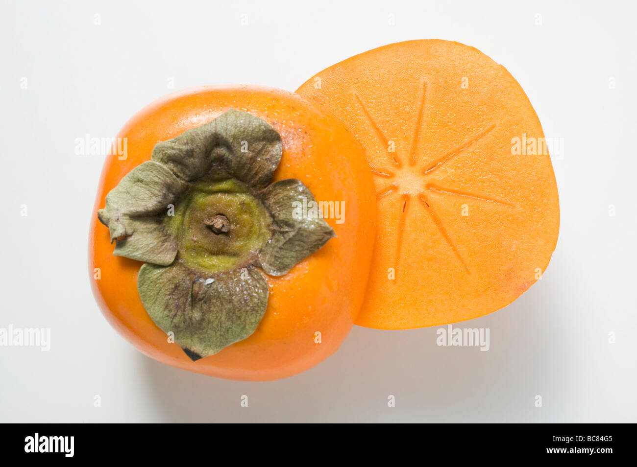 Persimmon, cut in half (overhead view Stock Photo - Alamy