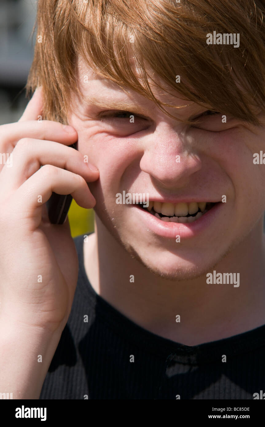 Young English white male teenager looking angry talking on a mobile ...