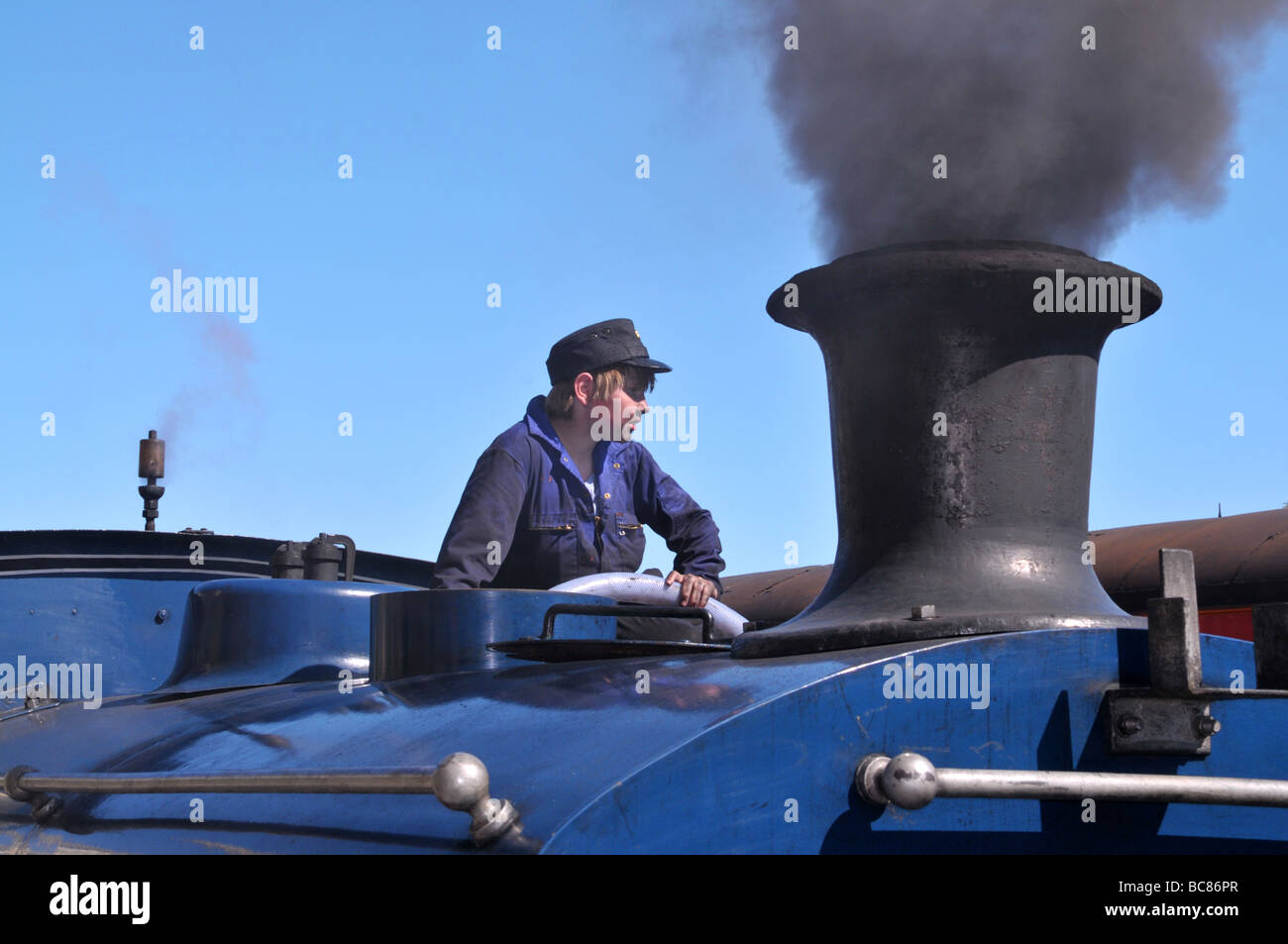A young boy refilling a steam train with water Stock Photo - Alamy