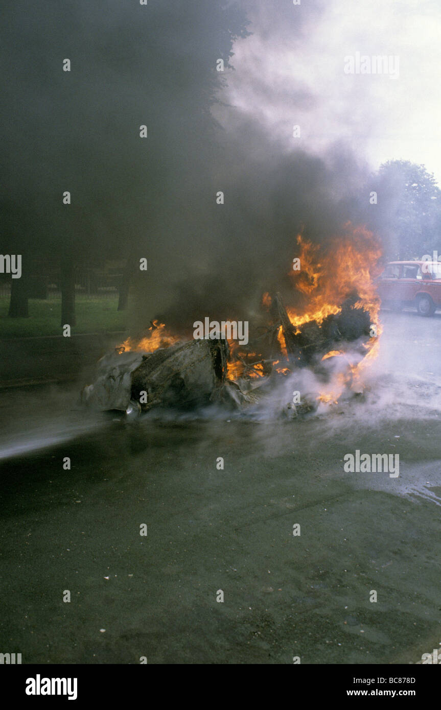 Car ablaze on fire in middle of street road billowing thick black smoke ...