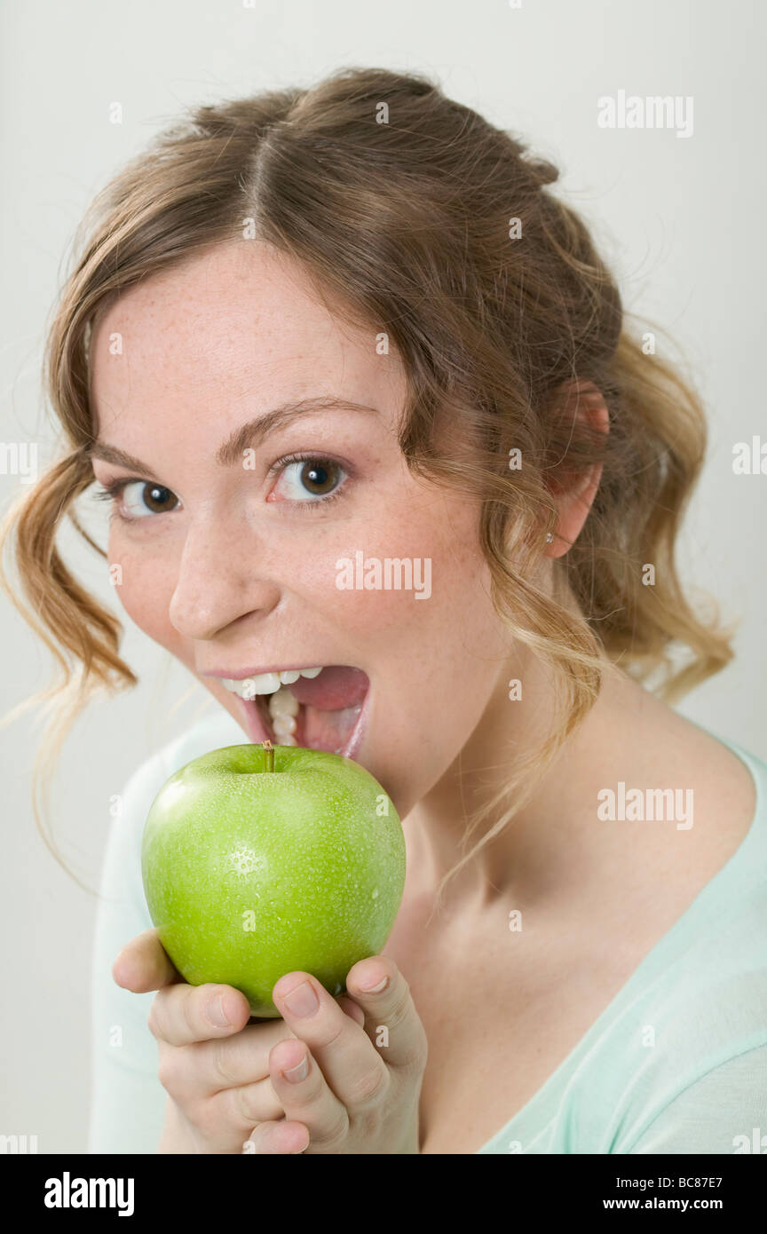 Woman biting into green apple Stock Photo - Alamy
