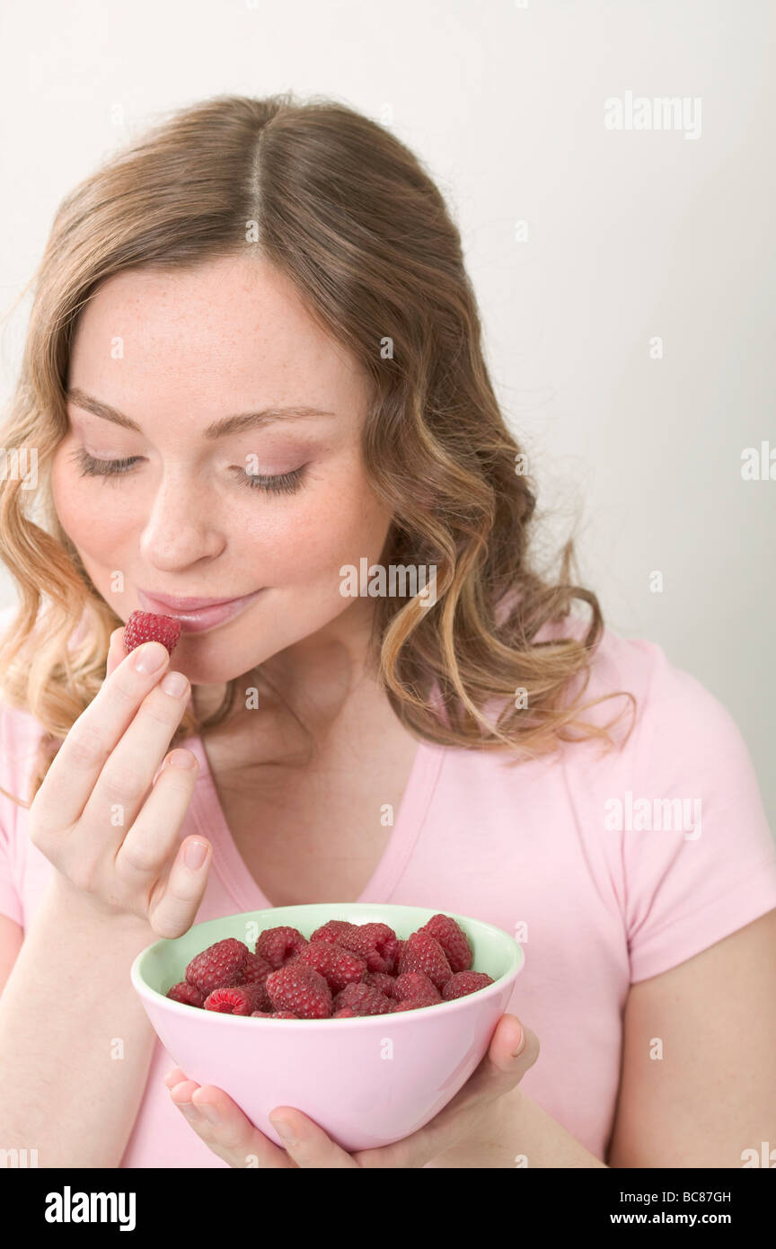 Woman smelling fresh raspberry Stock Photo - Alamy