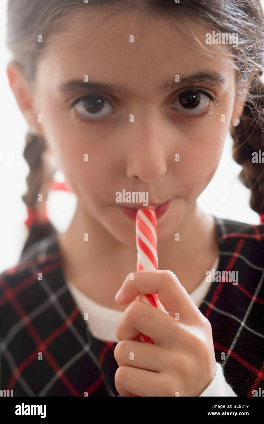 Girl eating candy stick Stock Photo - Alamy