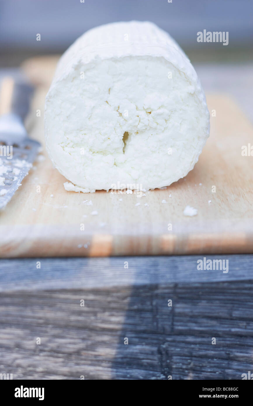 Goat's cheese roll on chopping board Stock Photo - Alamy