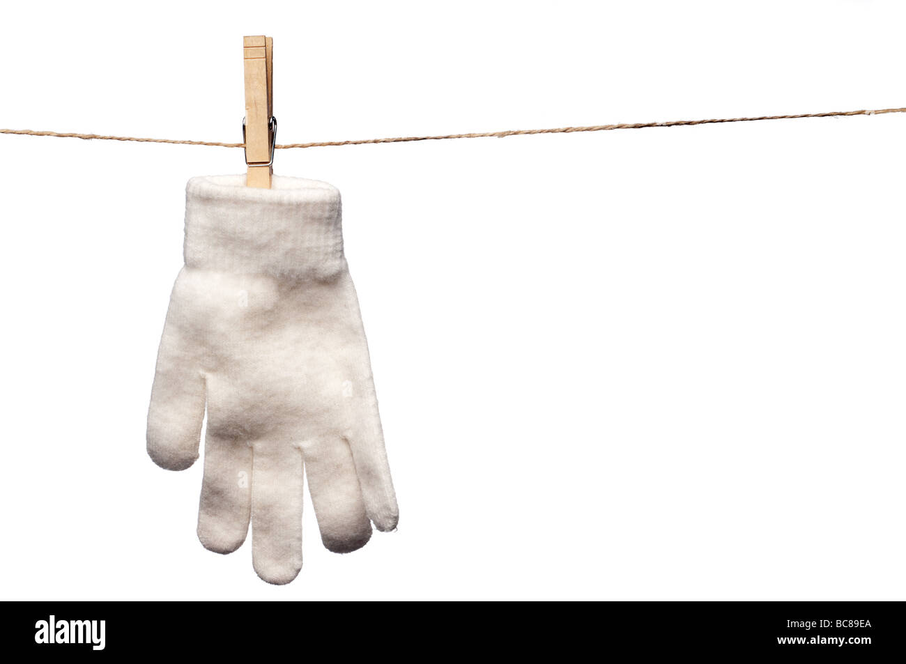 a horizontal image of a single white winter glove hanging on a clothes ...