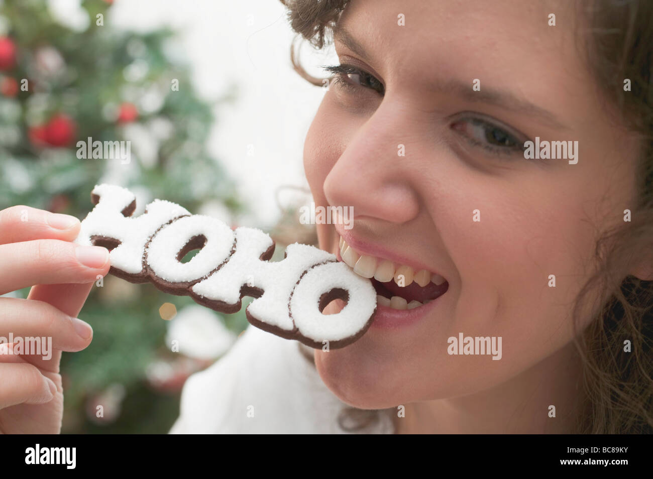Woman biting Christmas biscuit (the word HOHO Stock Photo - Alamy