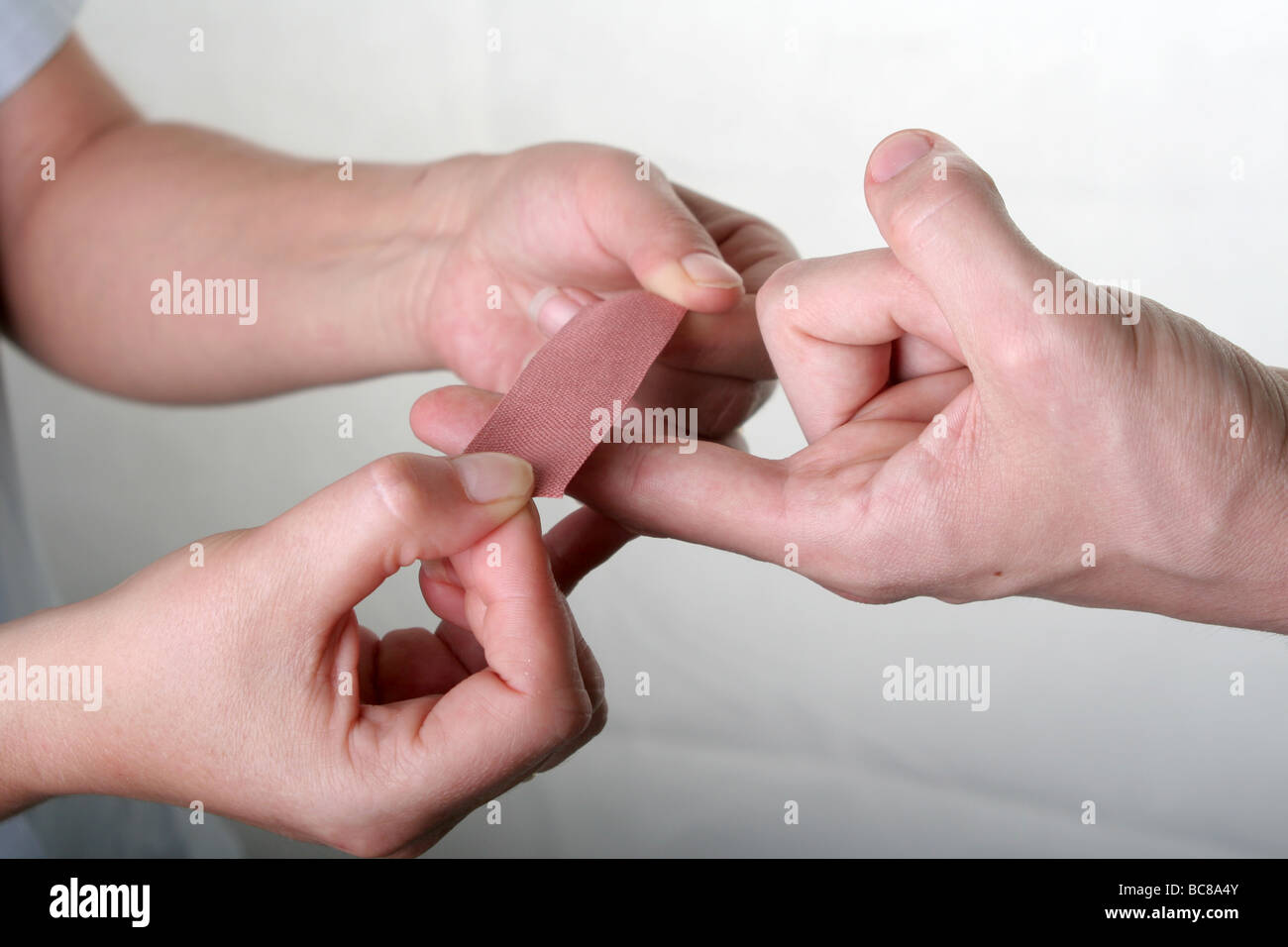 Putting plaster onto finger Stock Photo - Alamy