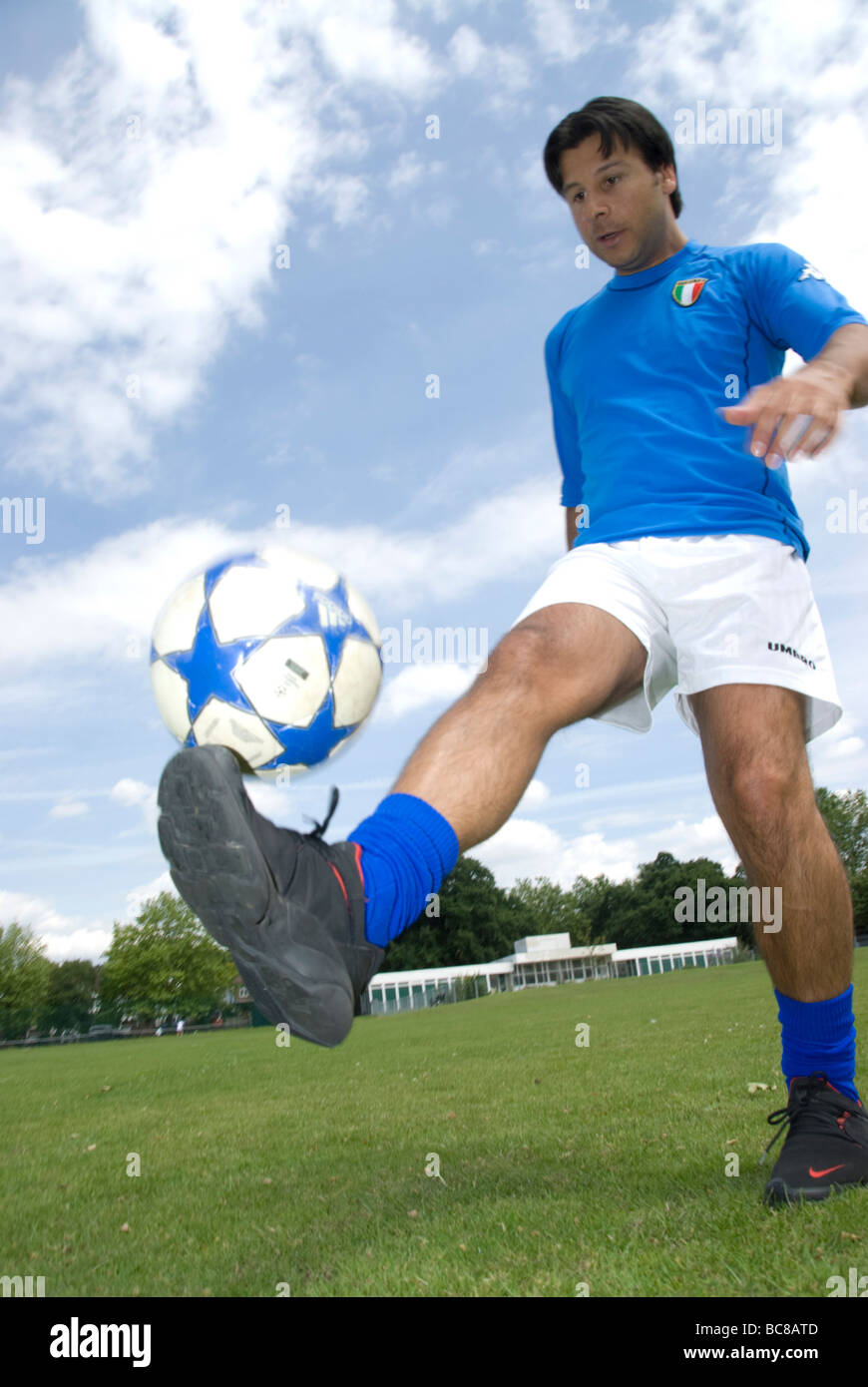 footballer in the park keeping a ball in the air with his foot Stock ...