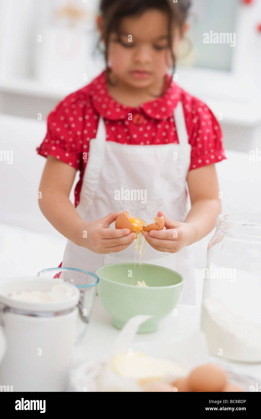 Small girl breaking an egg Stock Photo - Alamy
