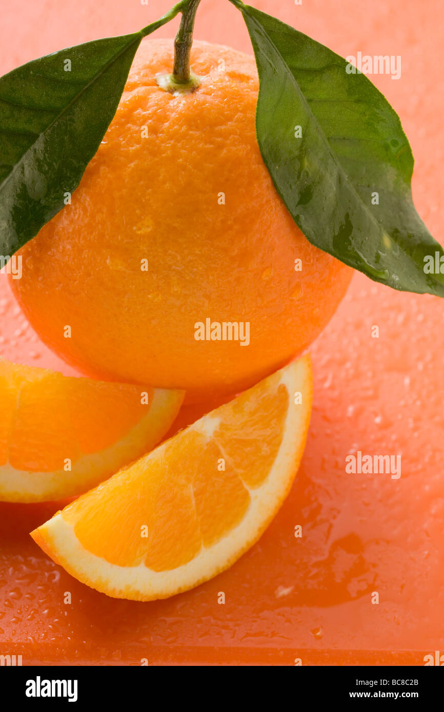 Orange with stalk and leaf, orange wedges Stock Photo - Alamy