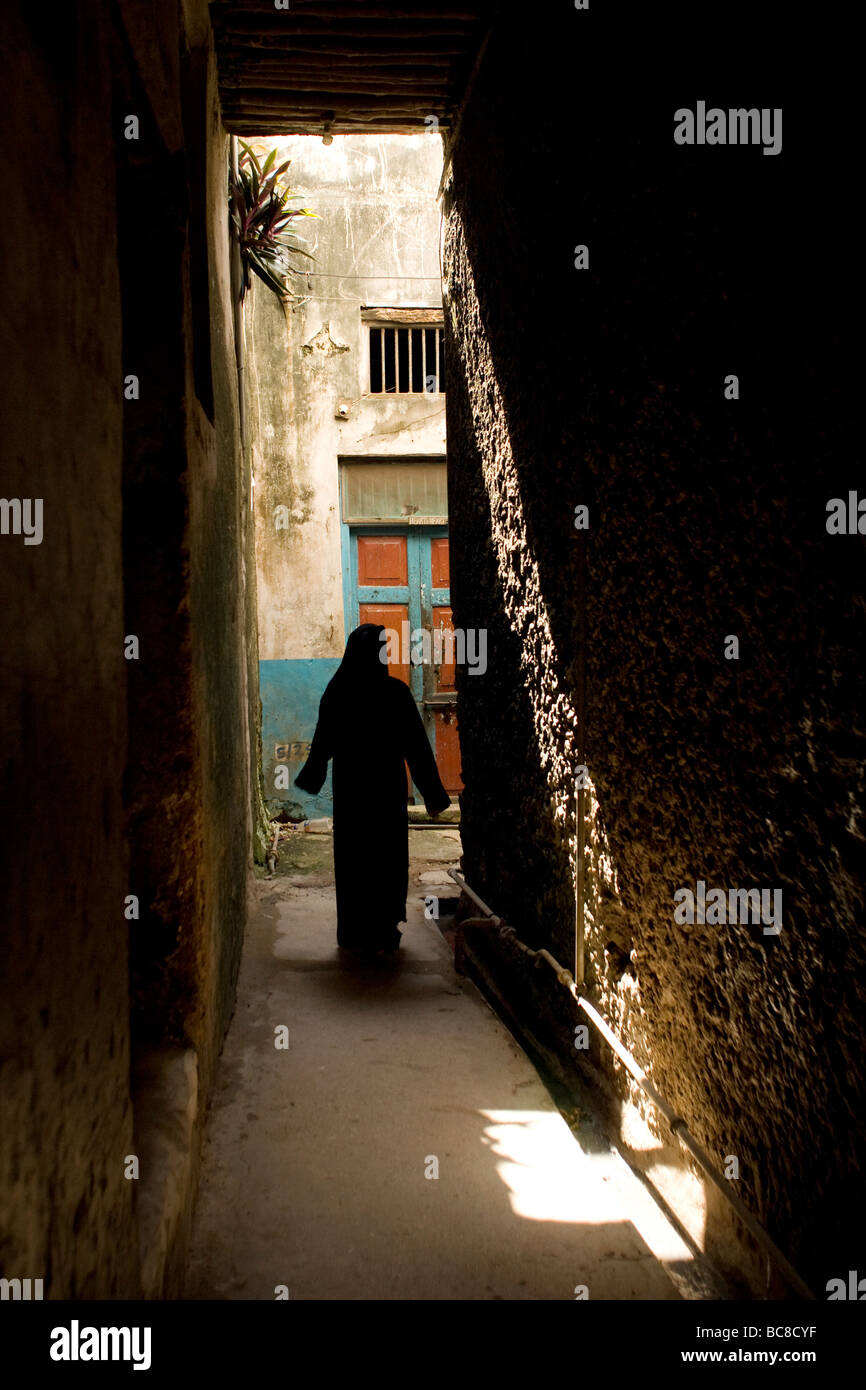 Woman walking down narrow stone streets of Lamu town - Lamu Island ...