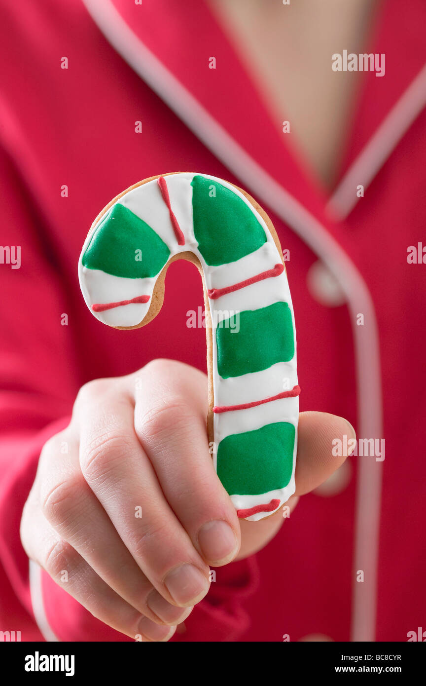 Hand holding candy cane biscuit Stock Photo - Alamy