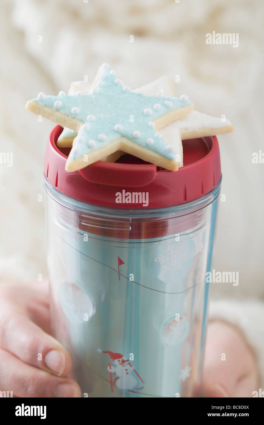 Woman holding star biscuit and insulated beaker Stock Photo - Alamy