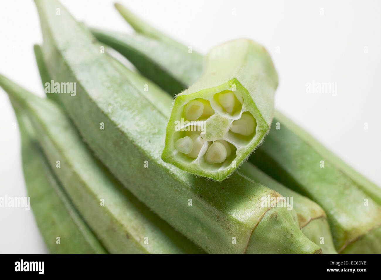 Several okra pods, one halved (close-up Stock Photo - Alamy