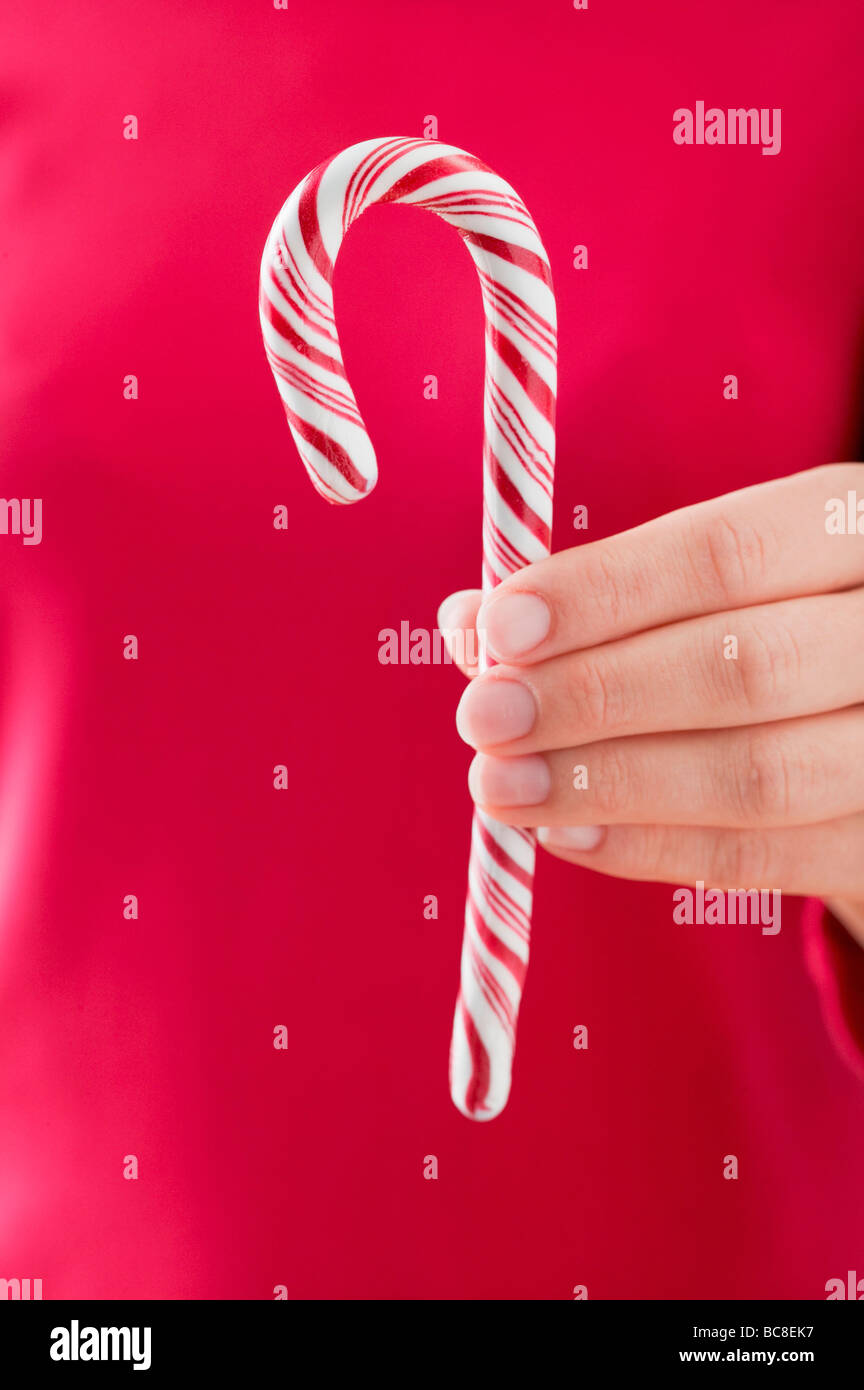 Hand holding candy cane Stock Photo - Alamy