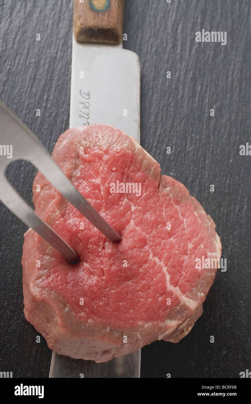 Pricking beef fillet with carving fork Stock Photo - Alamy