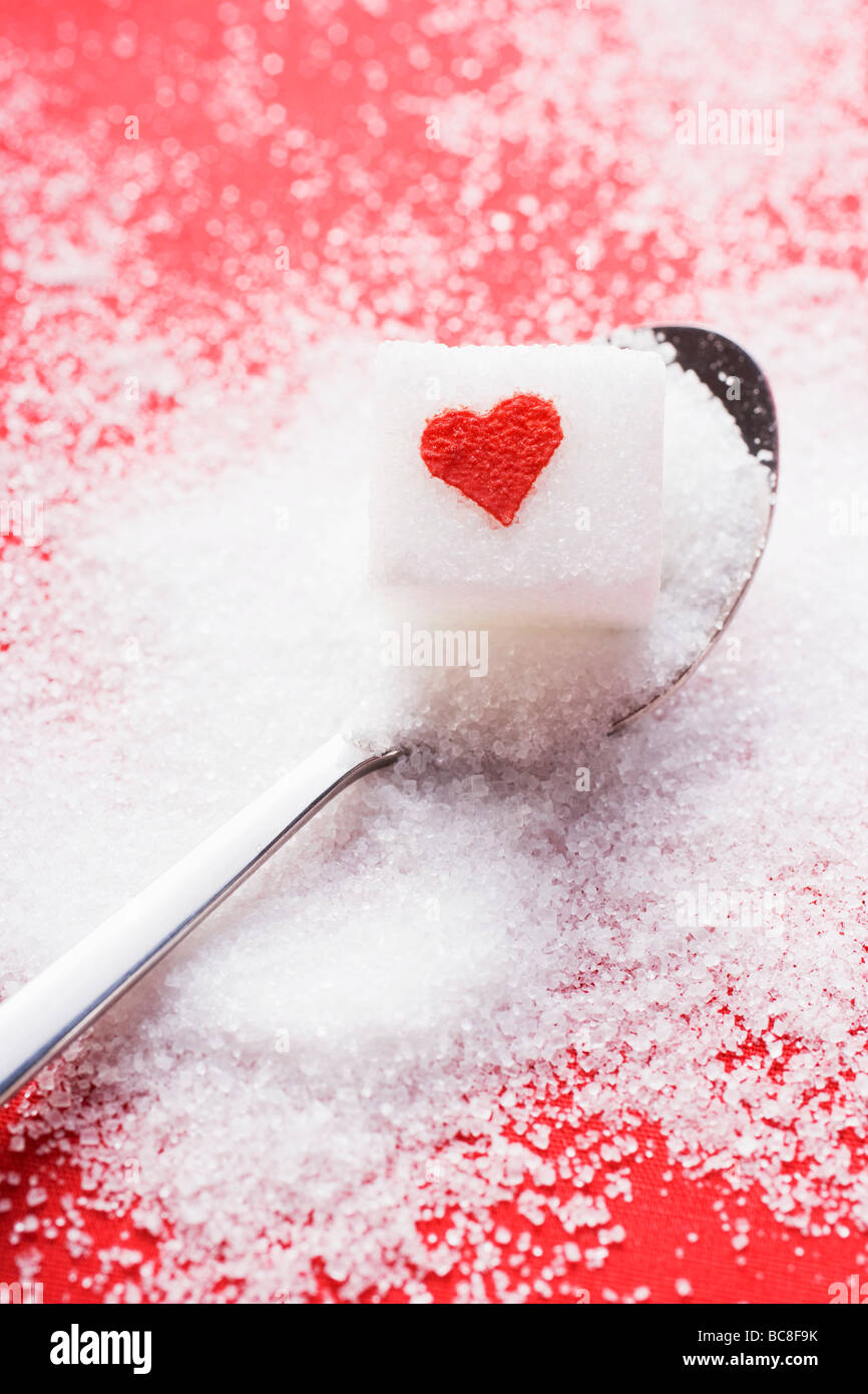 Sugar cube with red heart on spoon Stock Photo - Alamy
