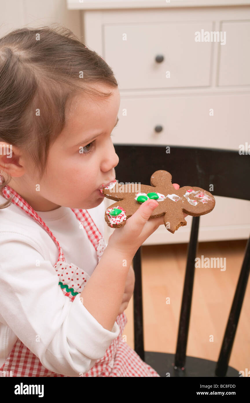 Small girl eating gingerbread man Stock Photo - Alamy