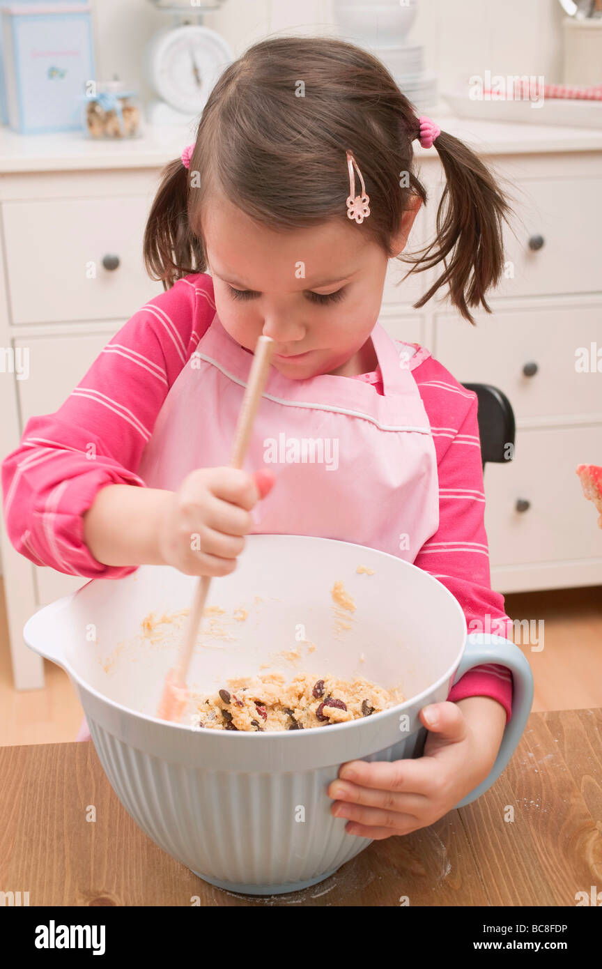 Small girl stirring mixture in mixing bowl Stock Photo - Alamy