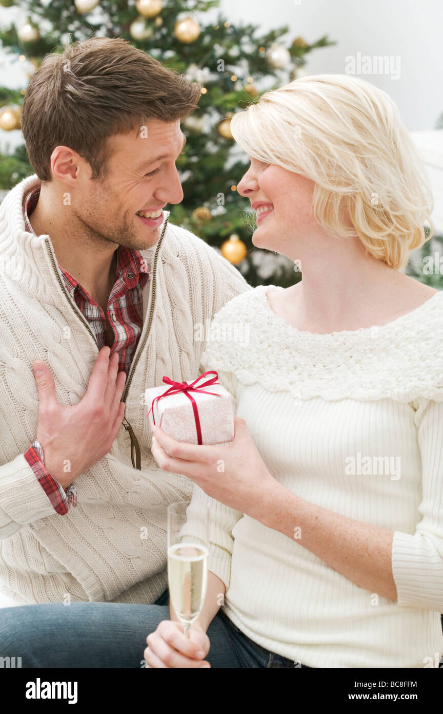 Woman giving man Christmas gift Stock Photo - Alamy