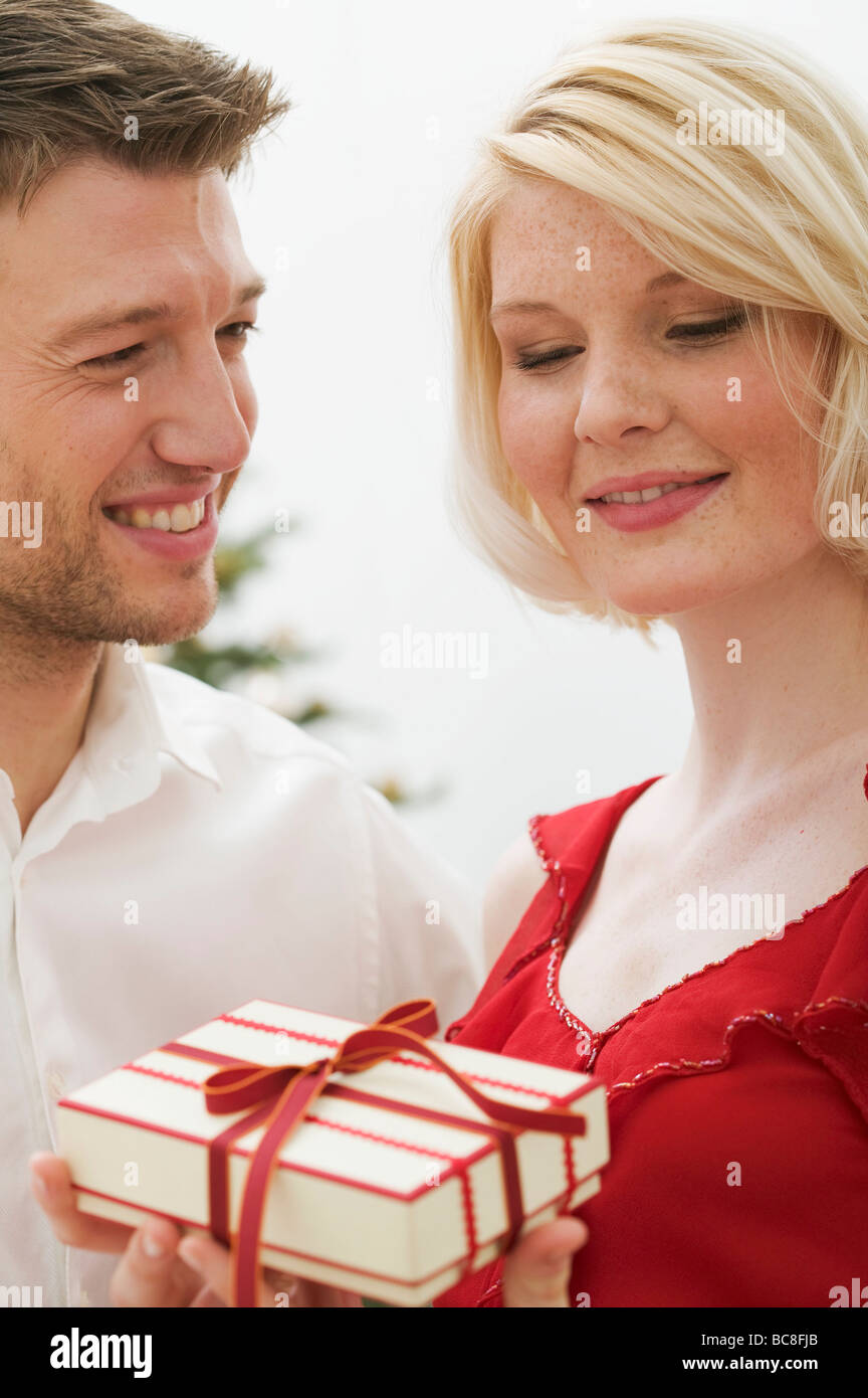 Man giving Christmas gift to woman Stock Photo - Alamy