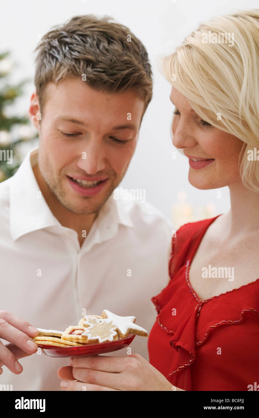 Woman offering man Christmas biscuits Stock Photo - Alamy