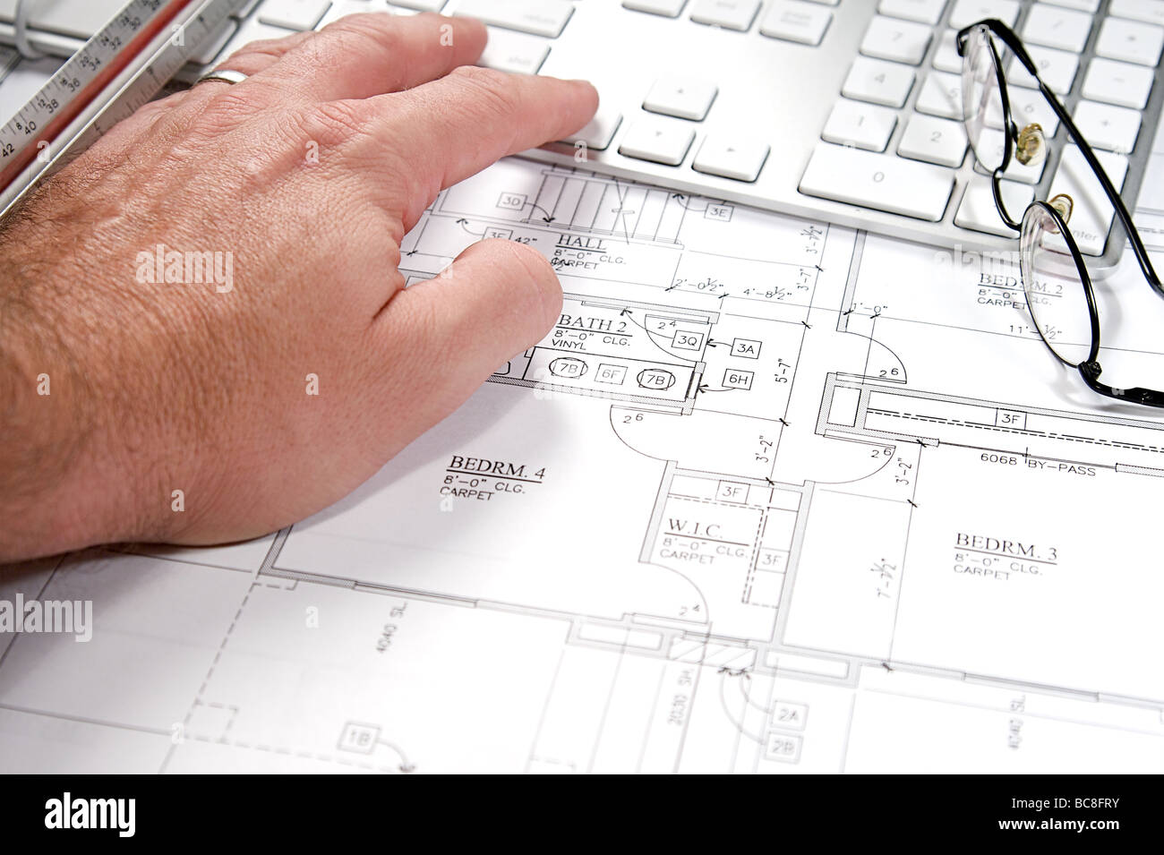 Modern architect using a CAD blueprint and a computer Stock Photo - Alamy