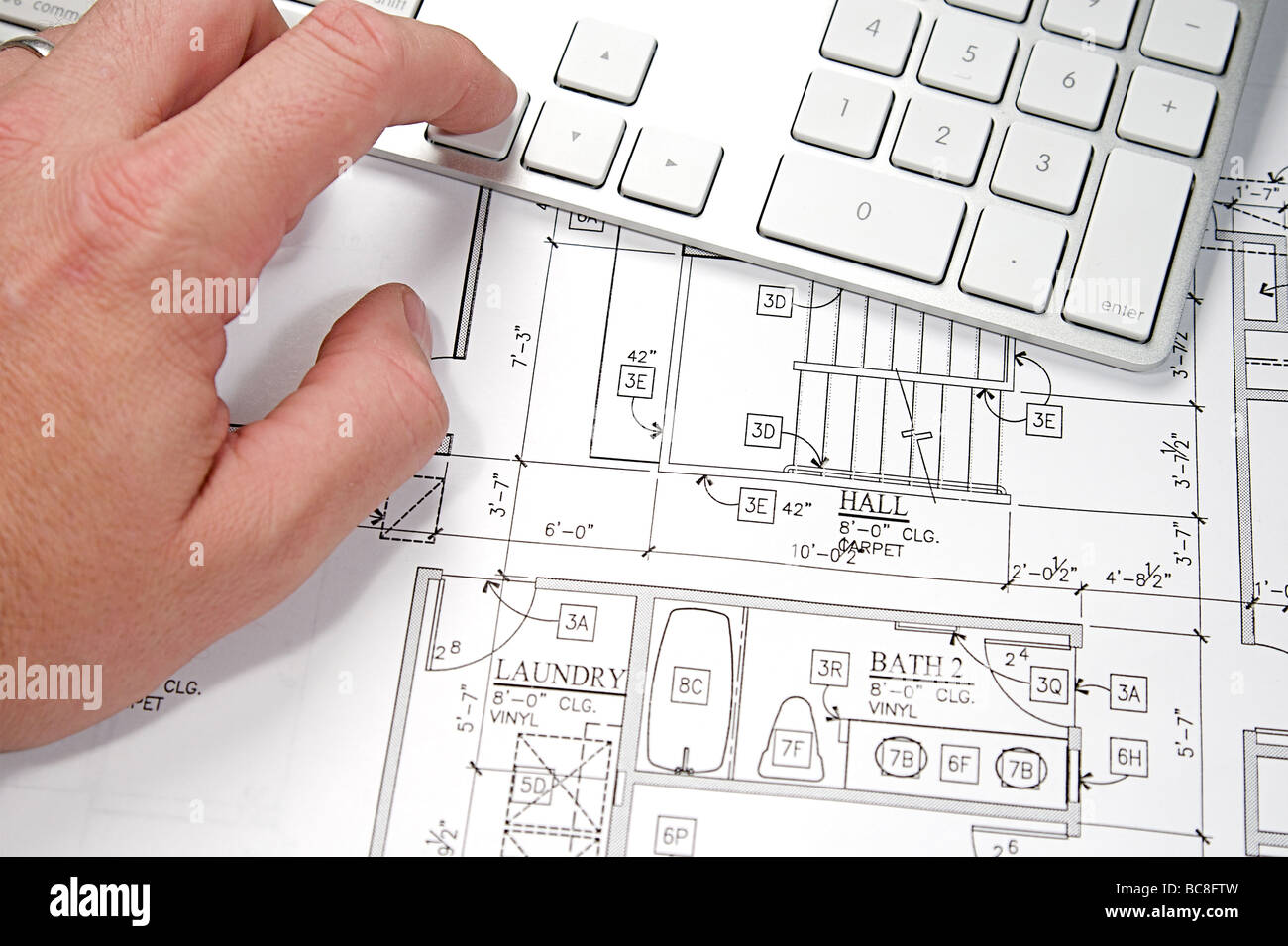 Modern architect using a CAD blueprint and a computer Stock Photo - Alamy