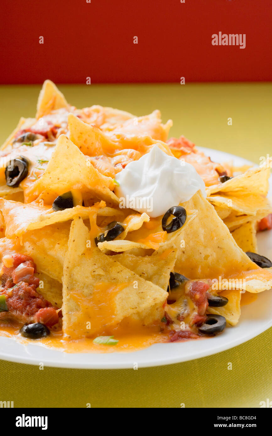 Nachos with melted cheese, olives and sour cream (Mexico Stock Photo ...