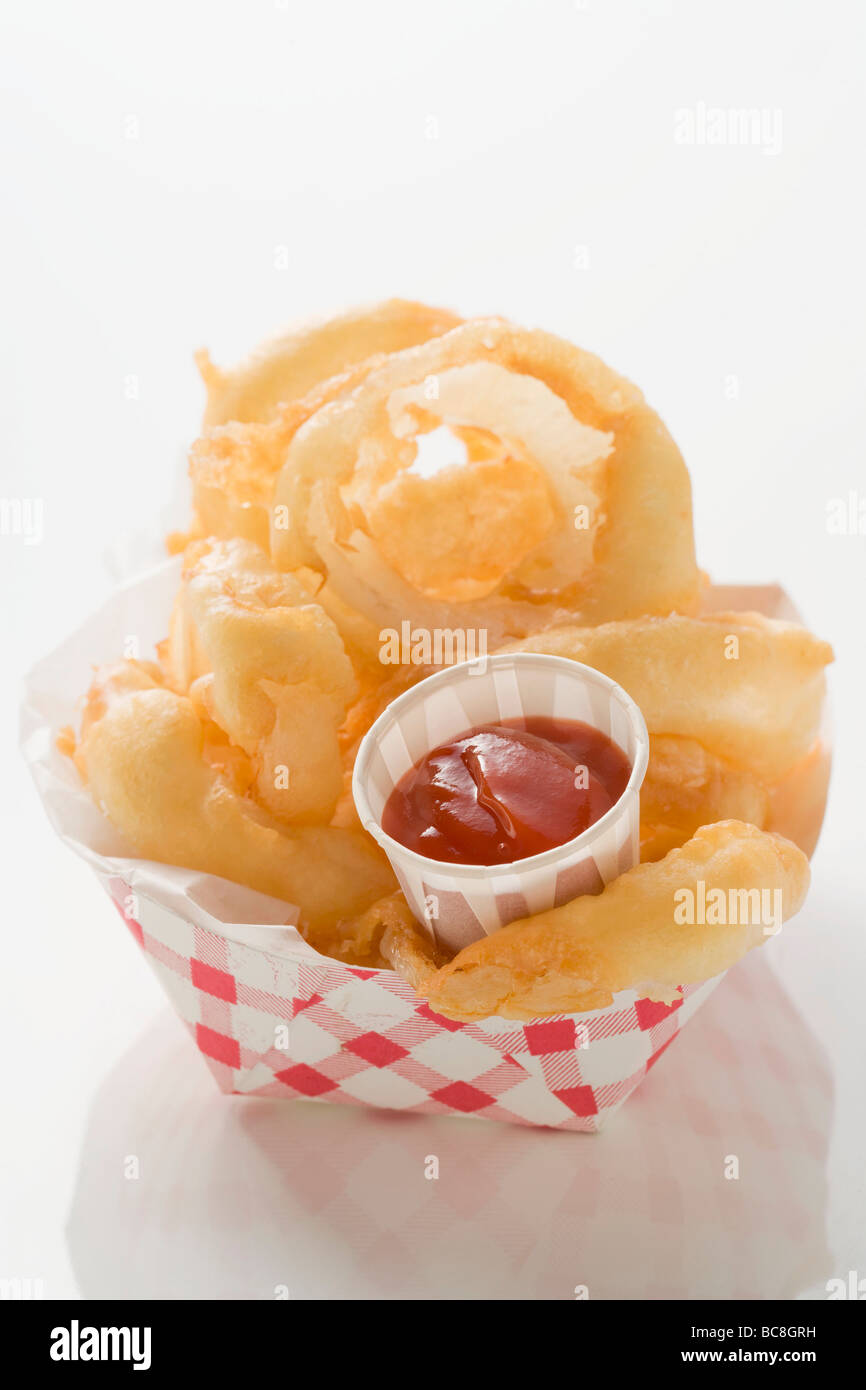 Deep-fried onion rings with ketchup in cardboard container Stock Photo ...