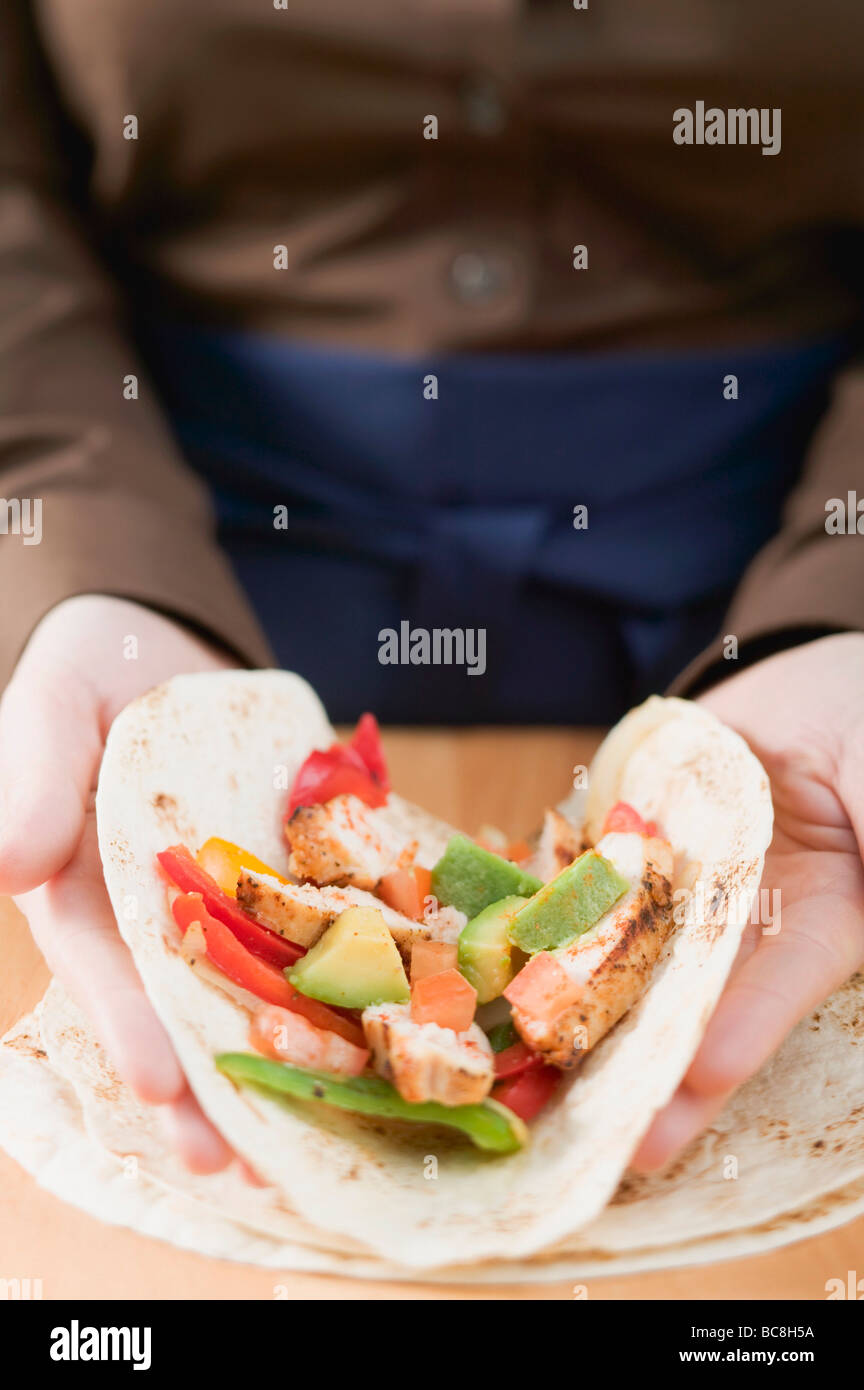 Hands folding a chicken-filled tortilla Stock Photo - Alamy