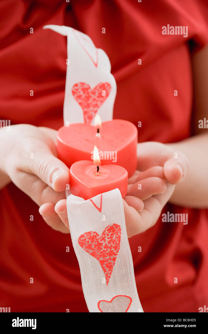 Hands holding two heart-shaped candles on ribbon Stock Photo - Alamy