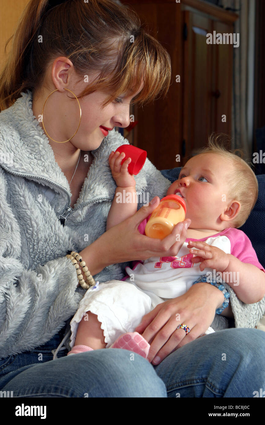 Happy teenage mum feeding baby girl Stock Photo - Alamy