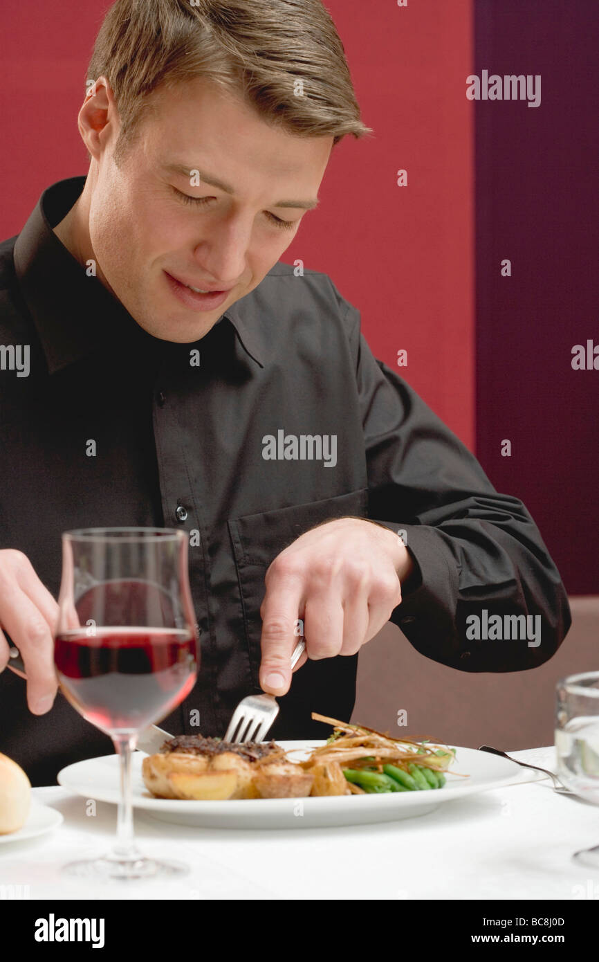 Man eating steak in restaurant Stock Photo - Alamy