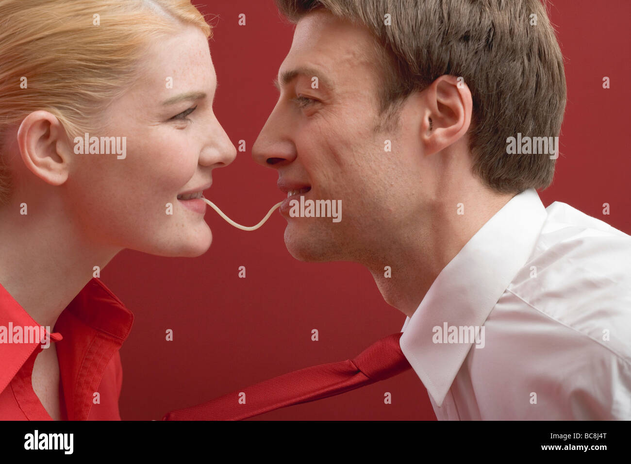 Couple eating a strand of spaghetti from both ends Stock Photo - Alamy