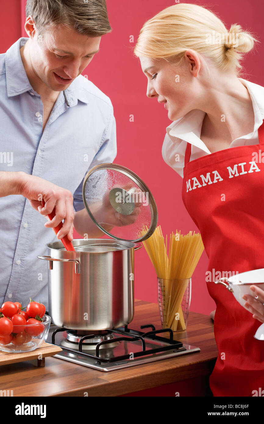 Couple cooking spaghetti with tomatoes Stock Photo - Alamy