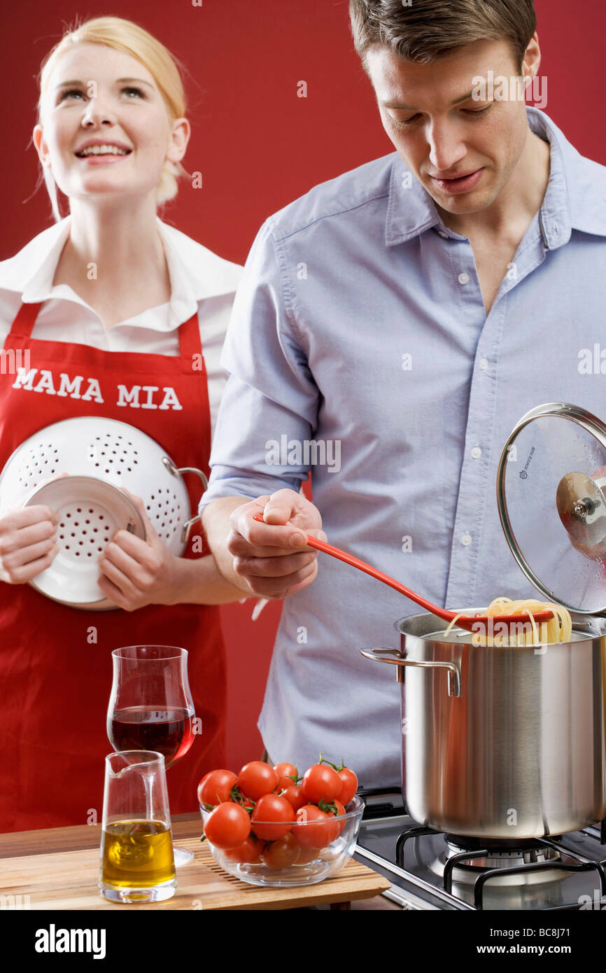 Couple cooking spaghetti with tomatoes Stock Photo - Alamy