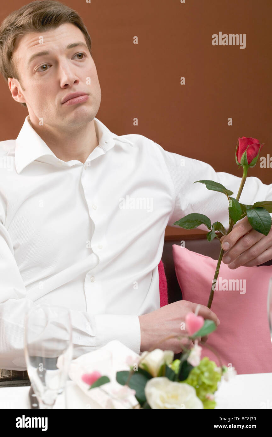 Lonely man with red rose in restaurant Stock Photo - Alamy