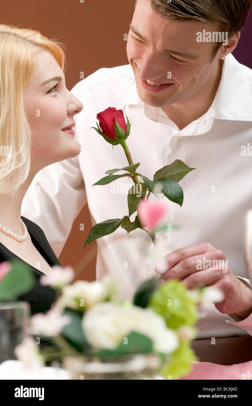 Man giving woman a red rose Stock Photo - Alamy