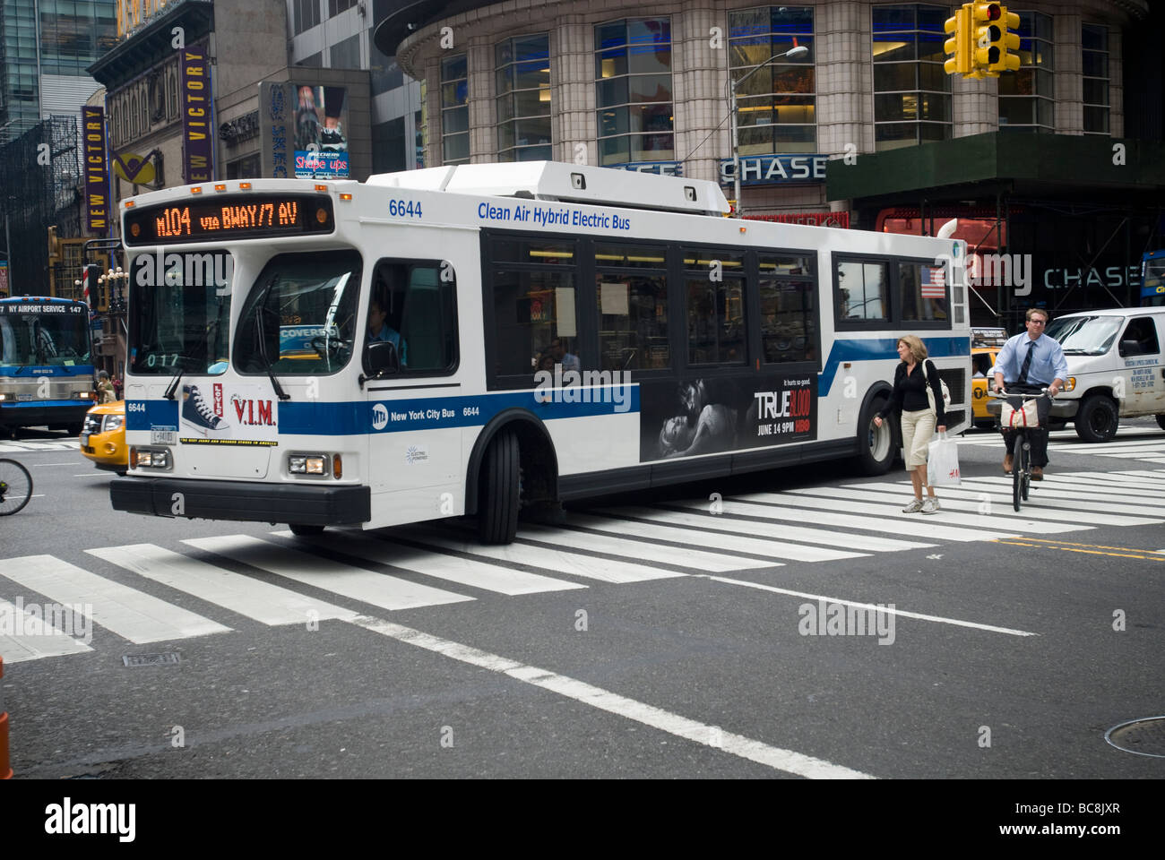 A hybrid electric powered MTA bus turns in traffic in Times Square in ...